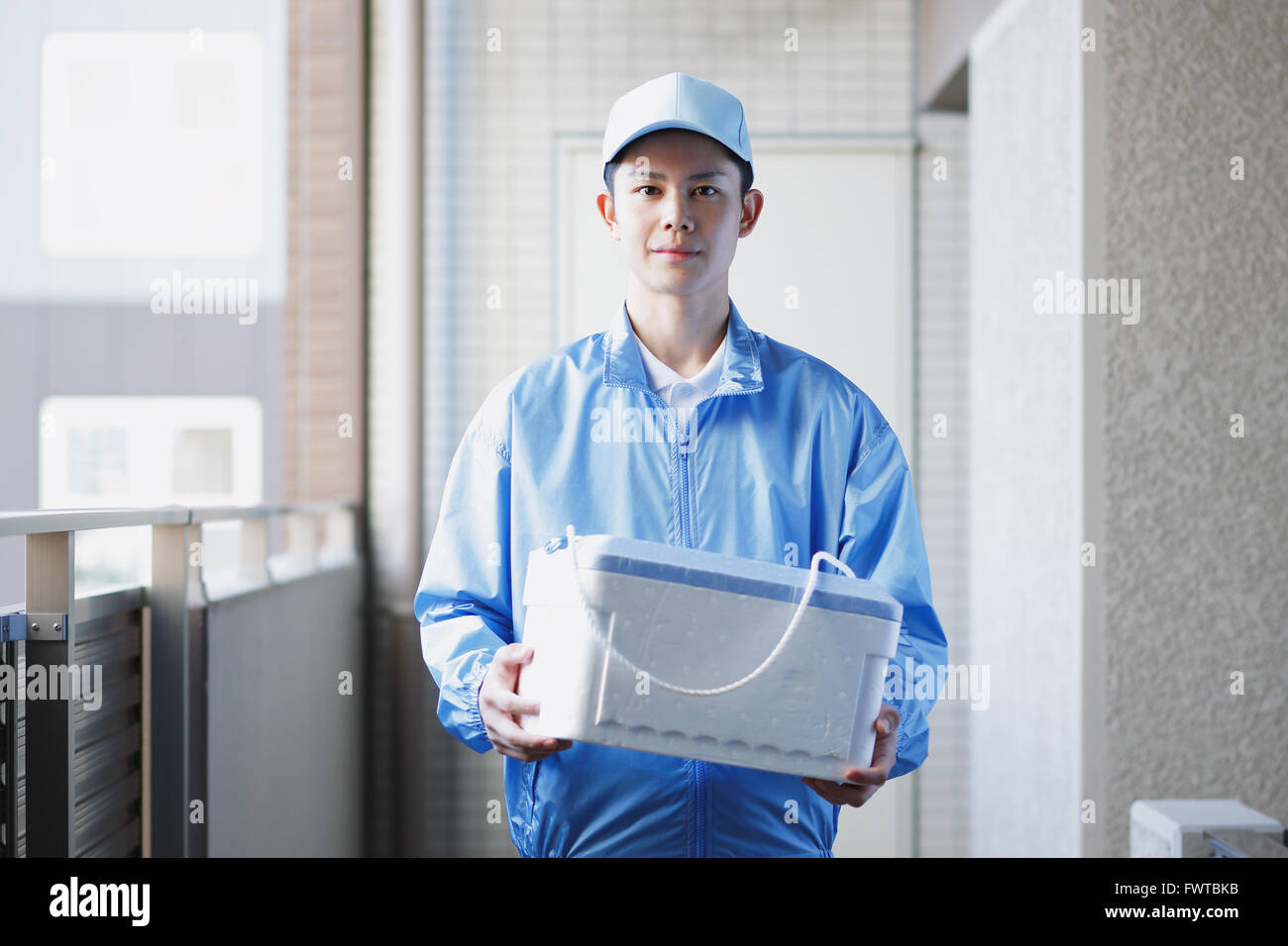 Young Japanese delivery man with box Stock Photo - Alamy