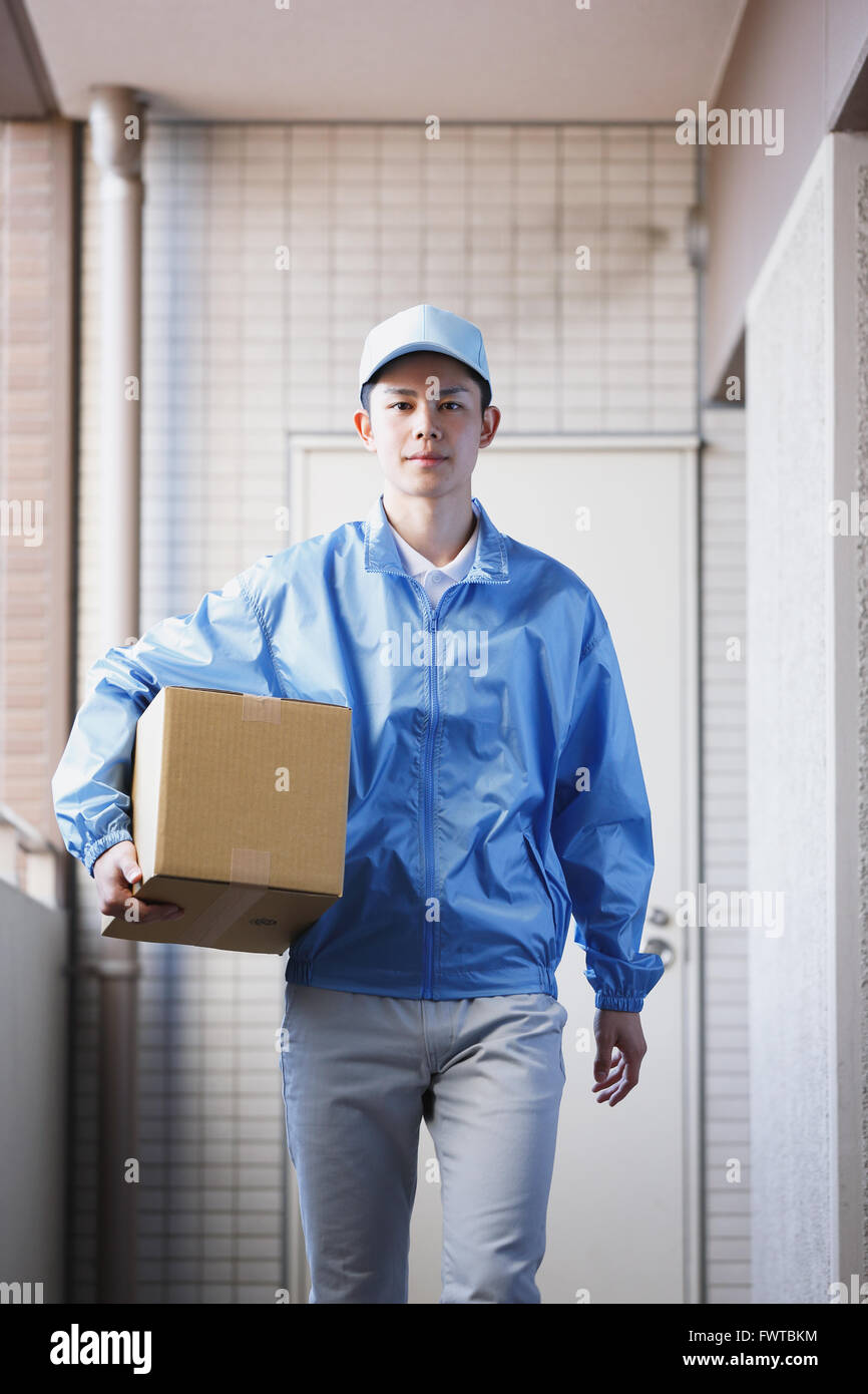 Young Japanese delivery man with box Stock Photo - Alamy
