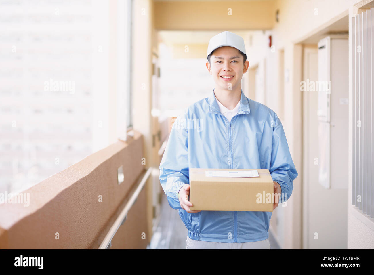 Young Japanese delivery man with box Stock Photo - Alamy