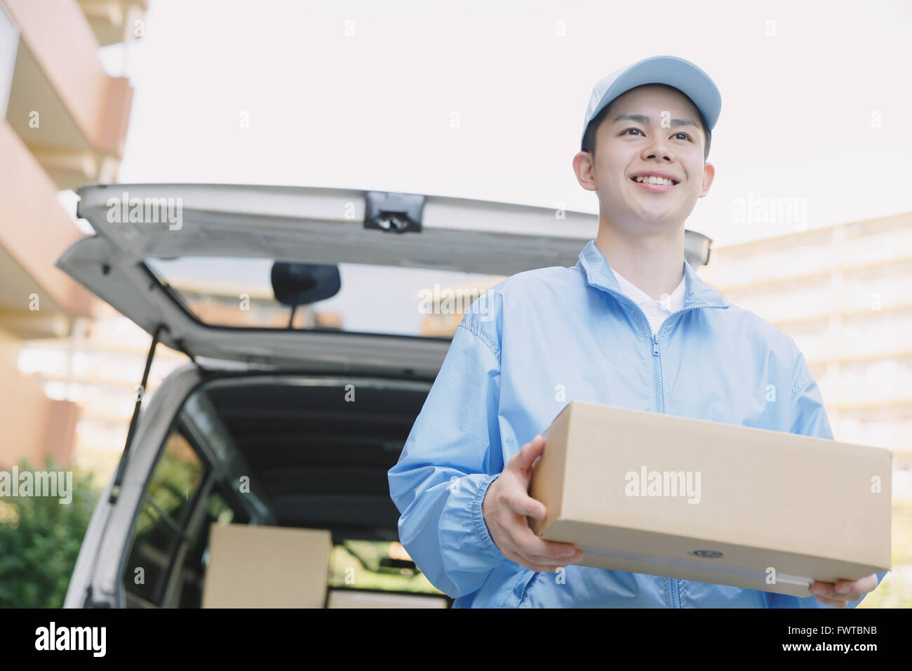 Young Japanese delivery man with box Stock Photo - Alamy