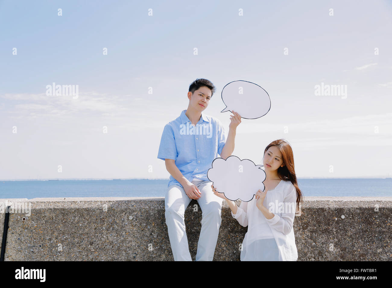 Young Japanese couple with message boards by the sea Stock Photo - Alamy