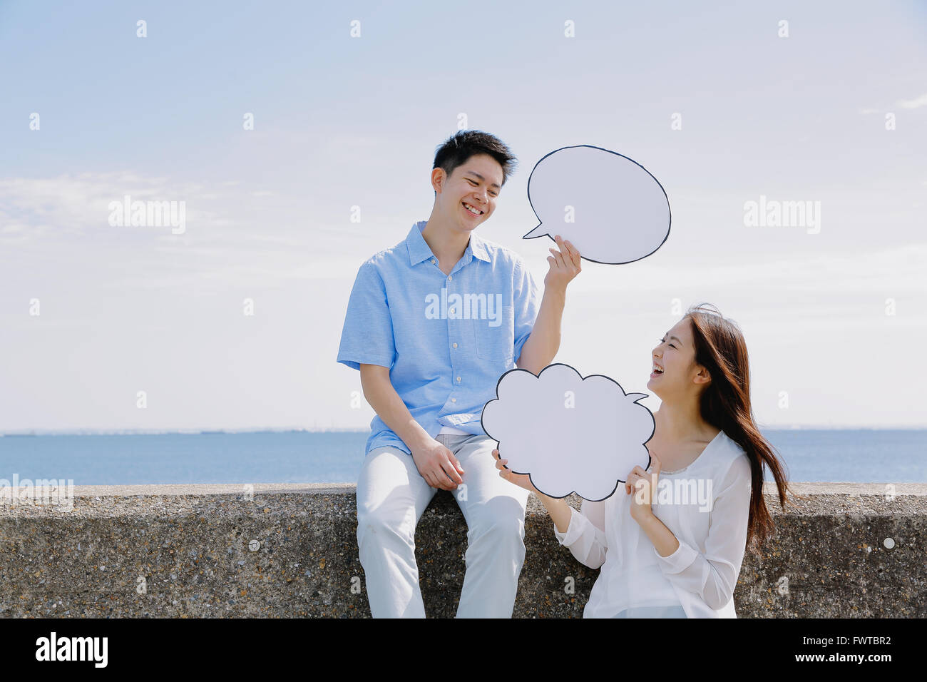 Young Japanese couple with message boards by the sea Stock Photo - Alamy