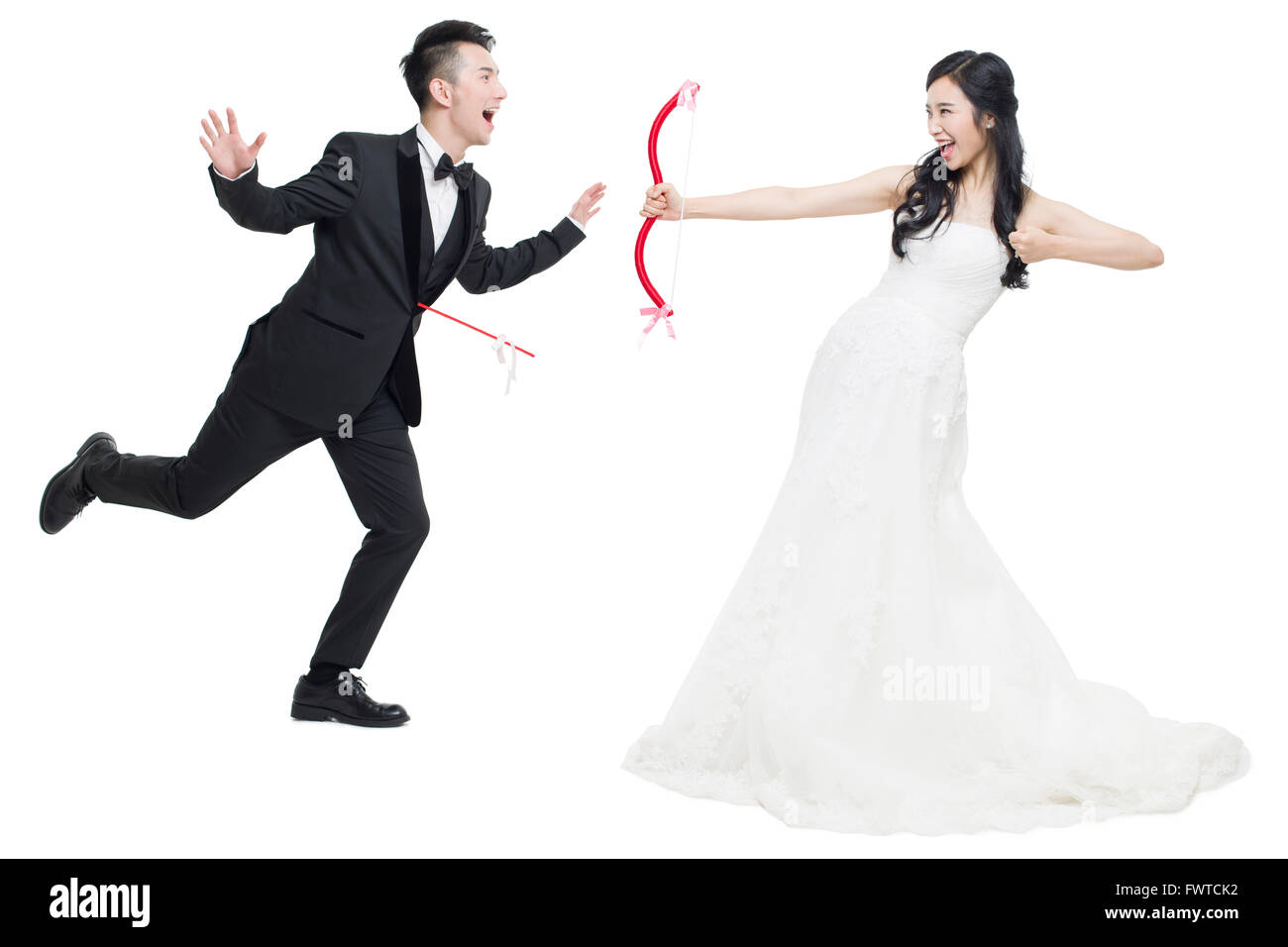 Happy bride and groom with bow and arrow Stock Photo - Alamy