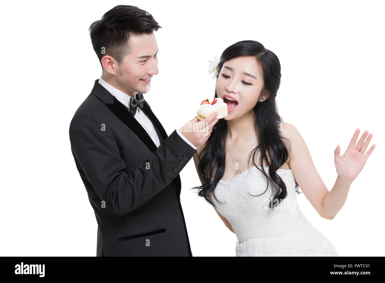 Happy bride and groom eating cake Stock Photo - Alamy