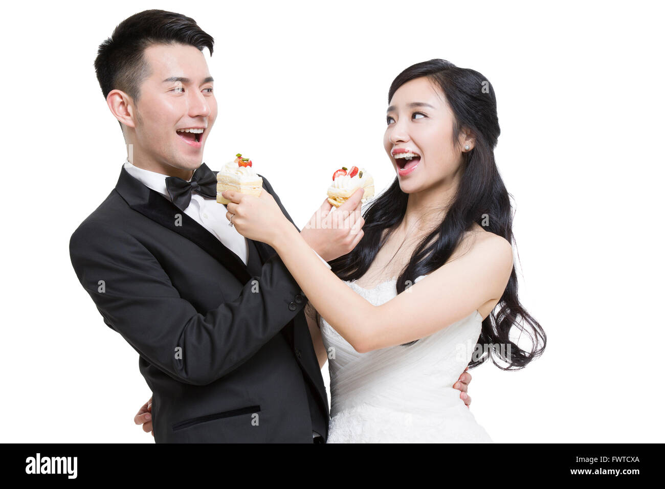 Happy bride and groom eating cake Stock Photo - Alamy