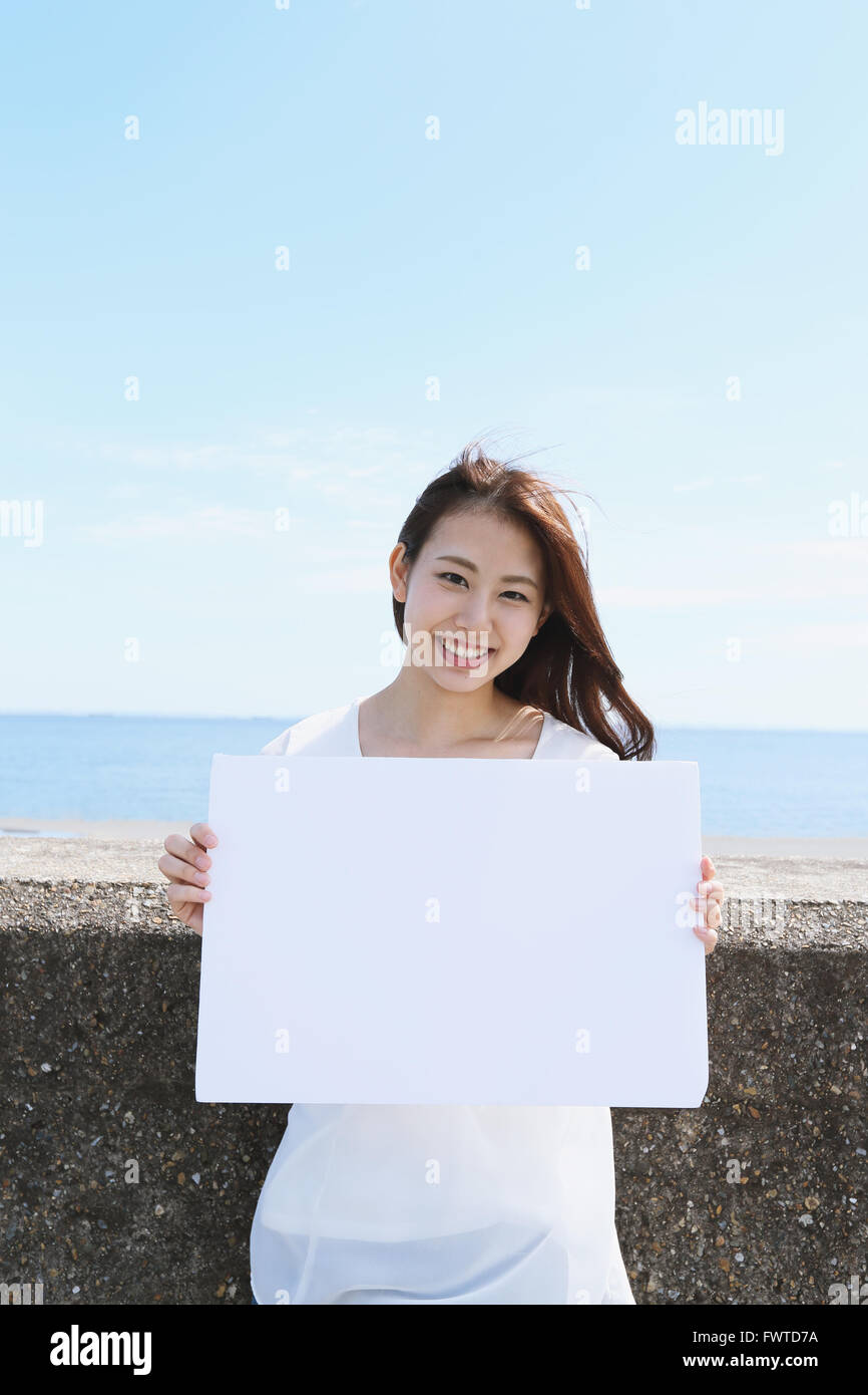 Young Japanese woman with whiteboard by the sea Stock Photo - Alamy
