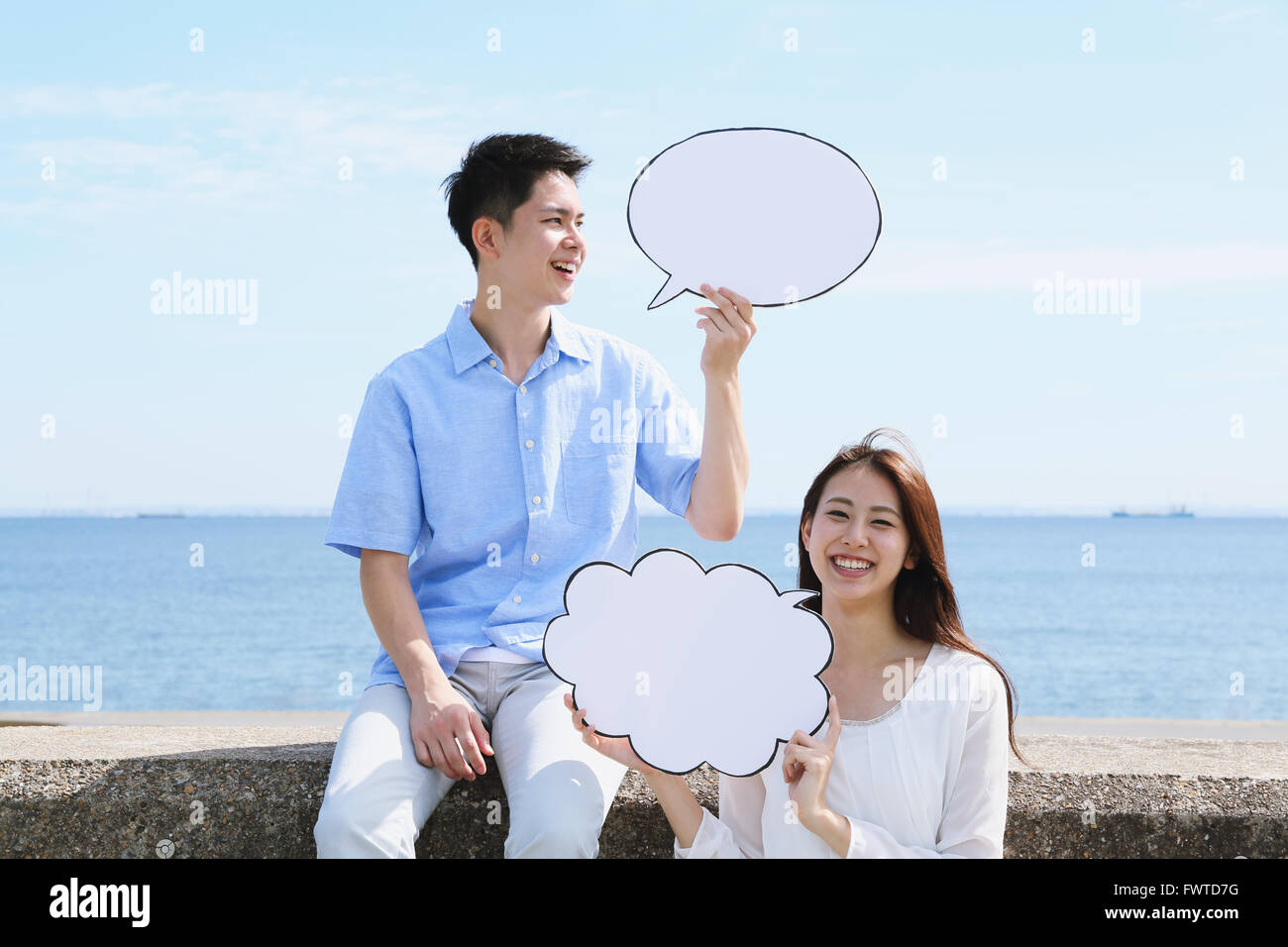 Young Japanese couple with message boards by the sea Stock Photo - Alamy