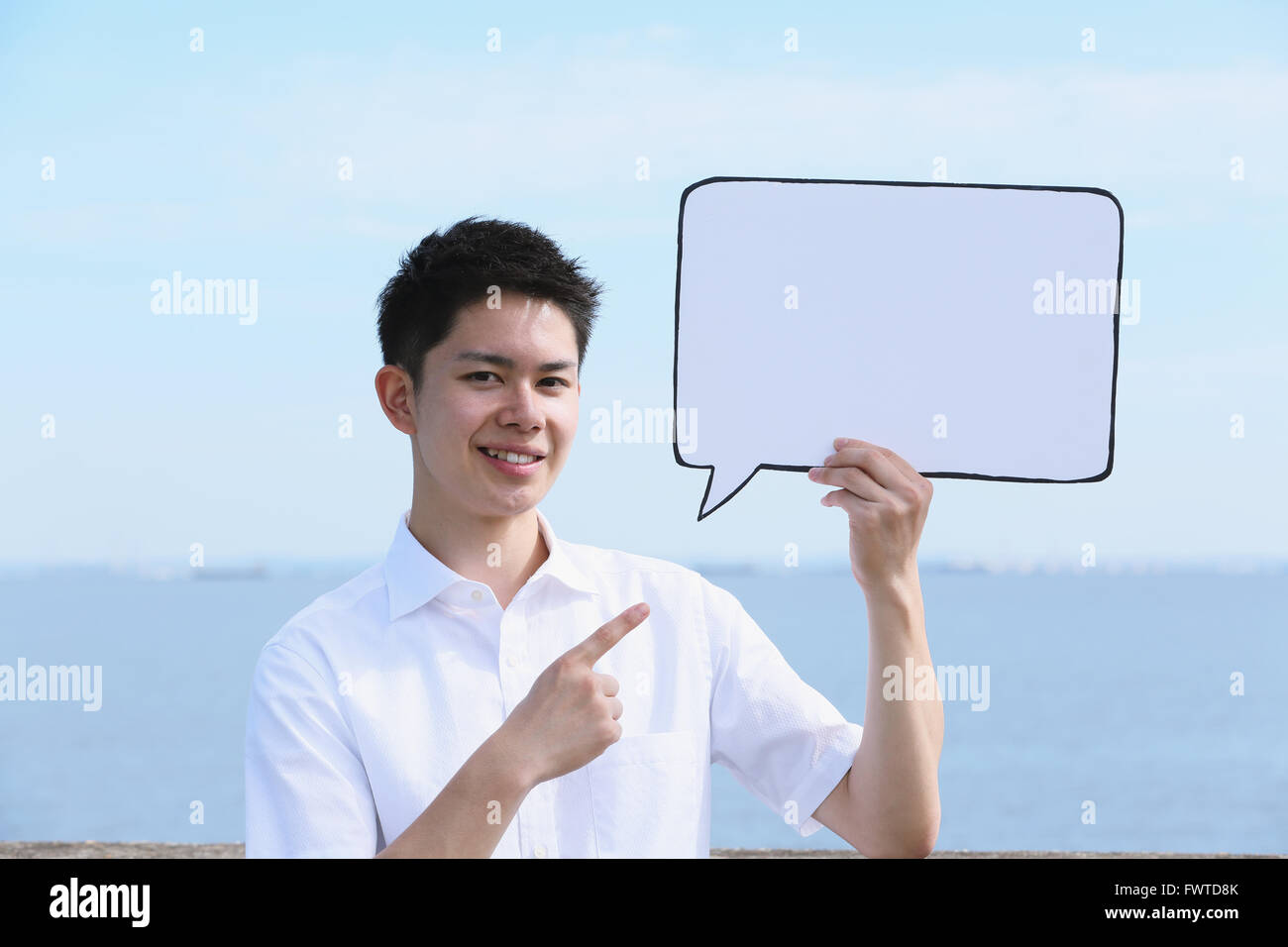 Young Japanese man with message board by the sea Stock Photo - Alamy