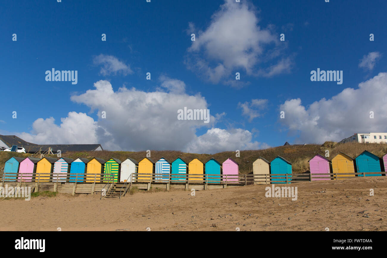 Beach huts traditional colourful English seaside scene with blue sky ...