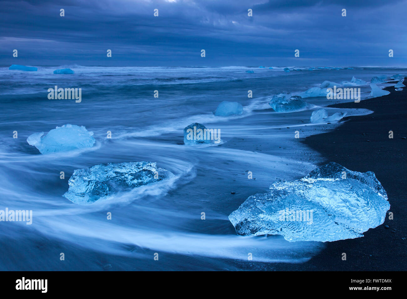 Melting blocks of ice washed on beach along the Atlantic Ocean ...
