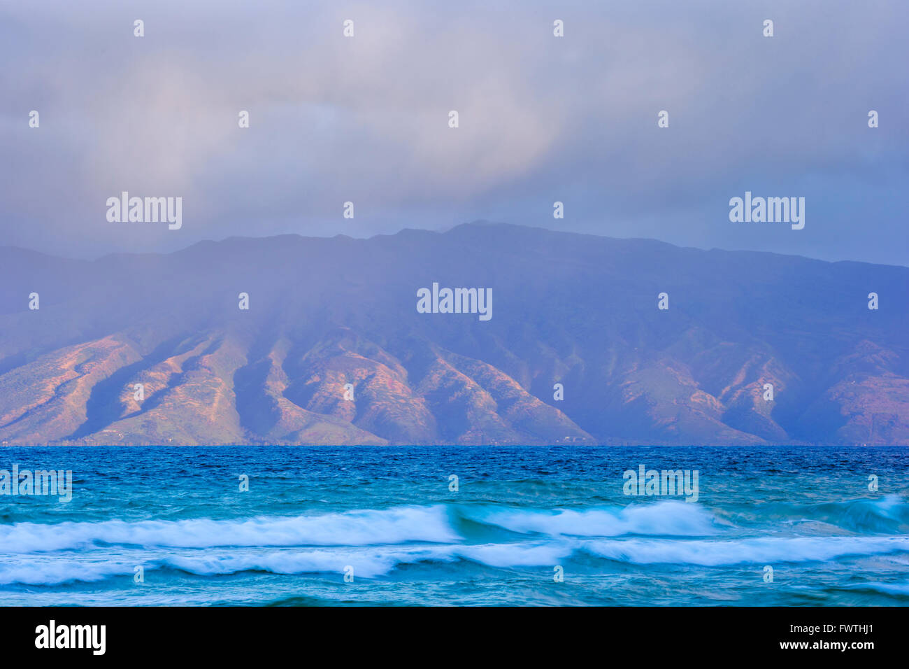 Molokai with rain clouds at sunrise seen from Maui Stock Photo - Alamy