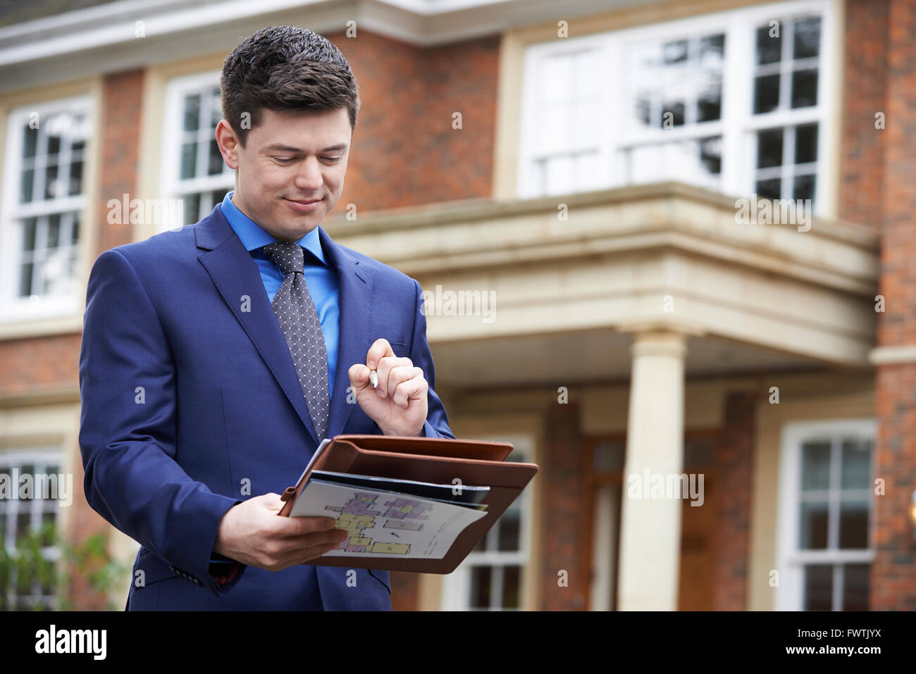Male Realtor Standing Outside Residential Property Stock Photo - Alamy