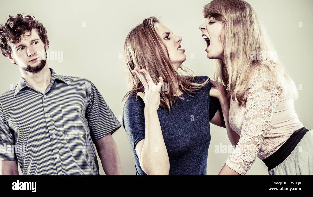 Aggressive mad women fighting over man. Young jealous girls wooing guy ...