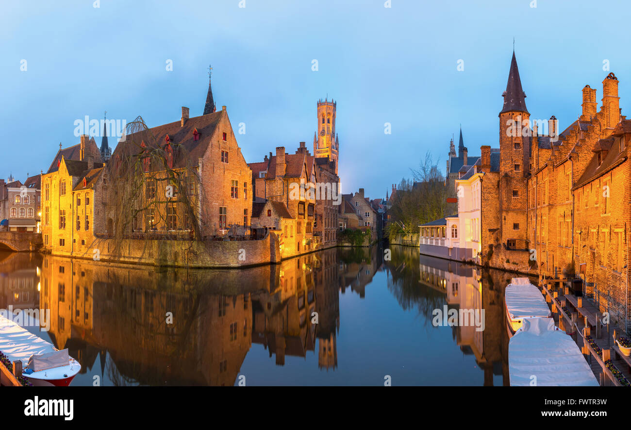 Historic medieval buildings along a canal in Bruges, Belgium at dusk ...