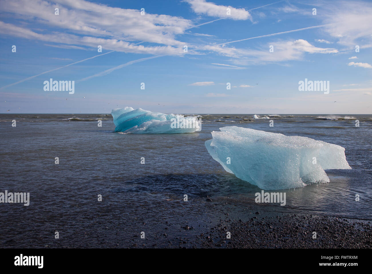 Two big chunks of glacier ice stranded on a lava beach in Iceland Stock ...