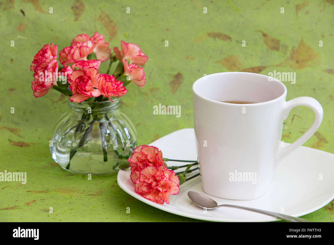 Small bouquet of Carnations set by a cup of tea Stock Photo - Alamy