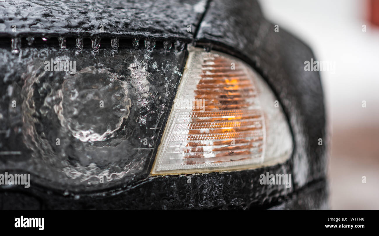Freezing rain, ice coated car. Headlight & signal light on black car ...