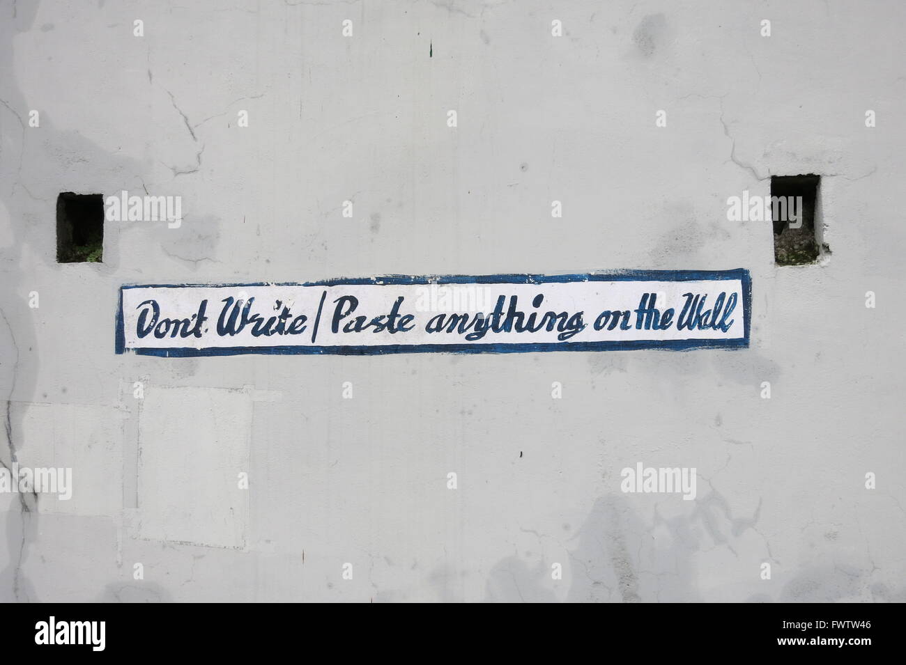 "Don't Write/Paste anything on the Wall" painted sign on a white wall ...