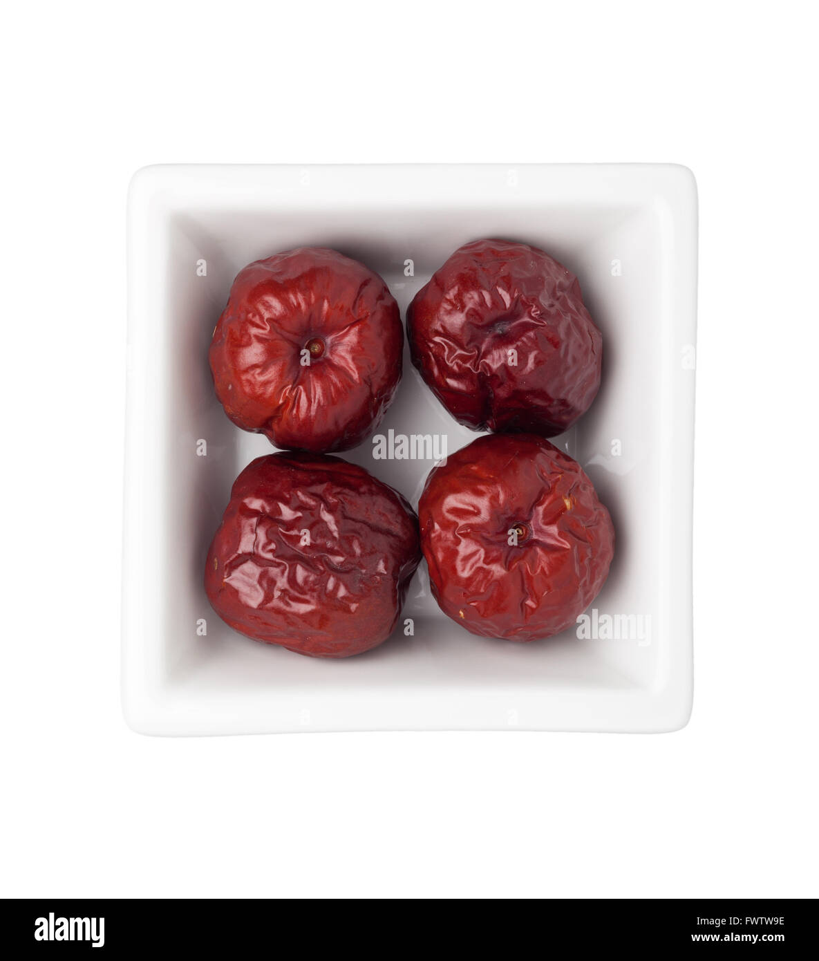 Dried big red jujubes in a square bowl isolated on white background ...