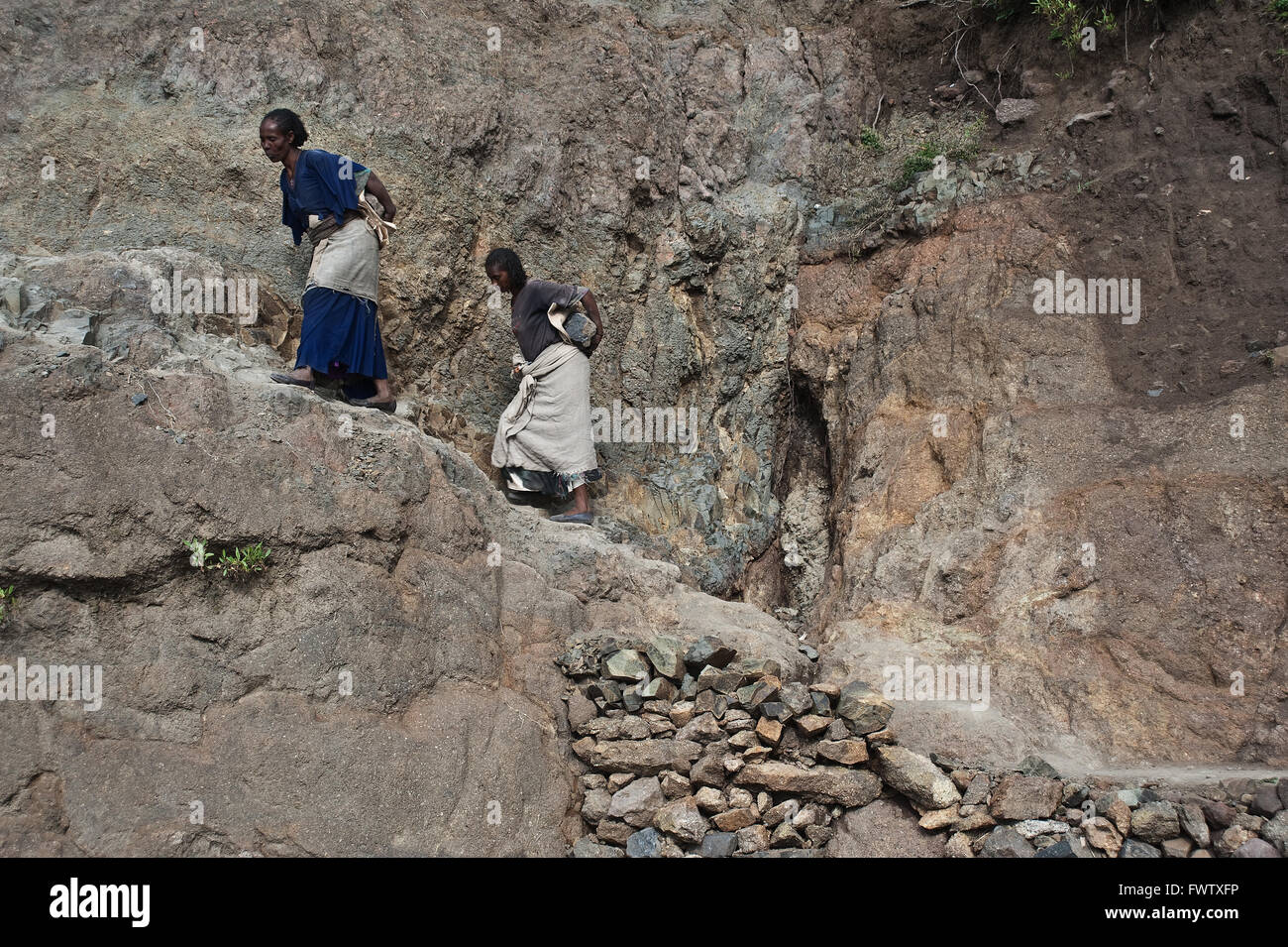 Irrigation works : two women are carrying stones to build an irrigation ...