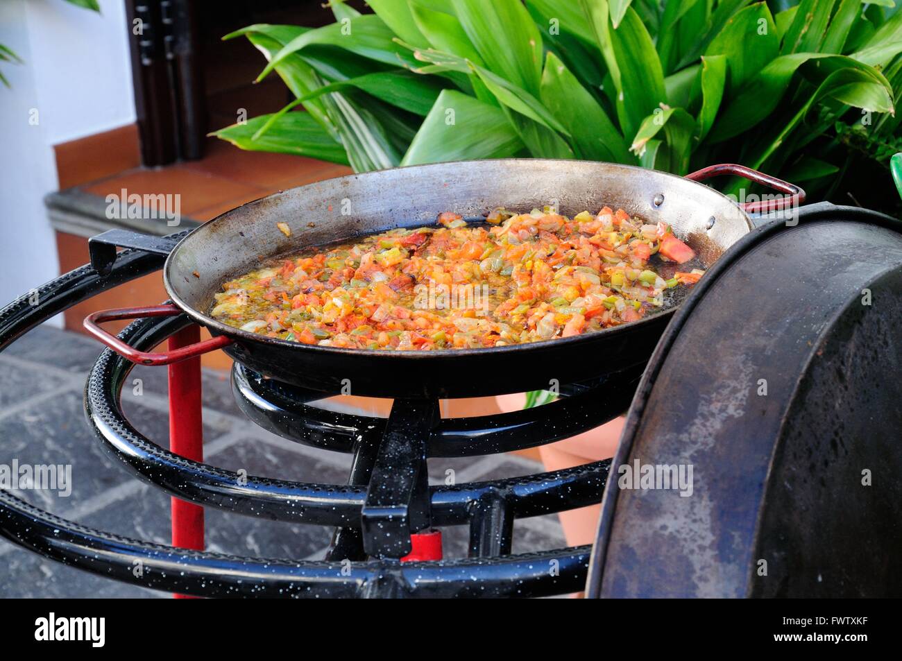 tomatoes added to paella cooking outside and left to simmer Andalusia ...