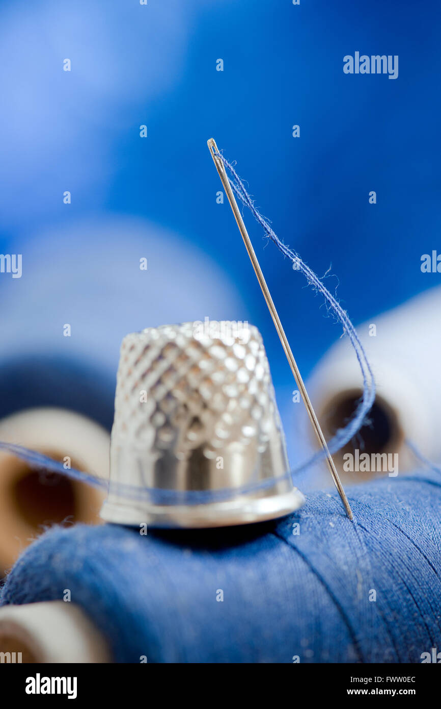 needle with blue thread on the blue background Stock Photo - Alamy