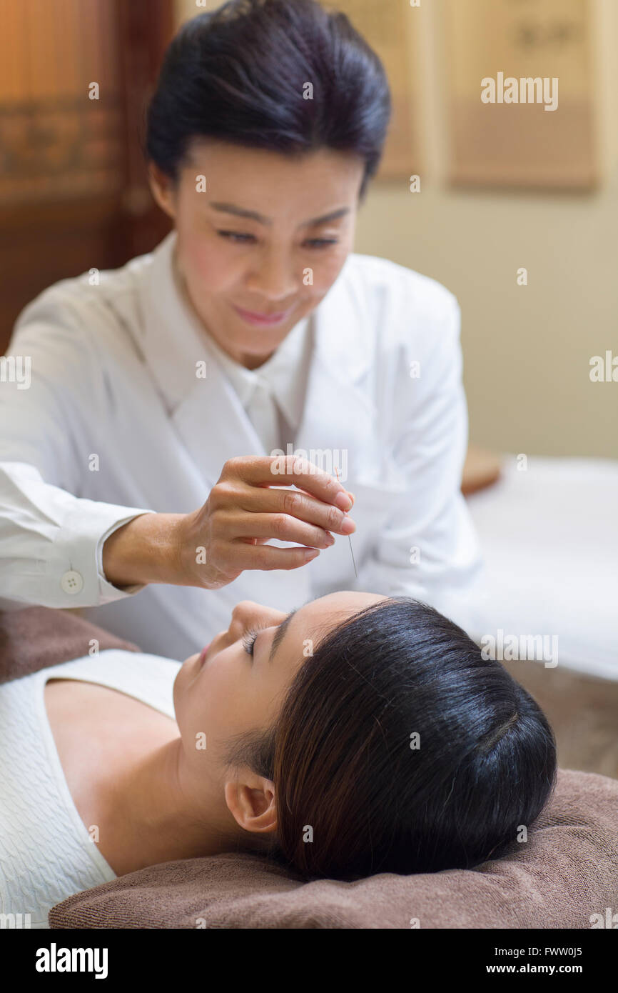 Young woman receiving acupuncture Stock Photo - Alamy