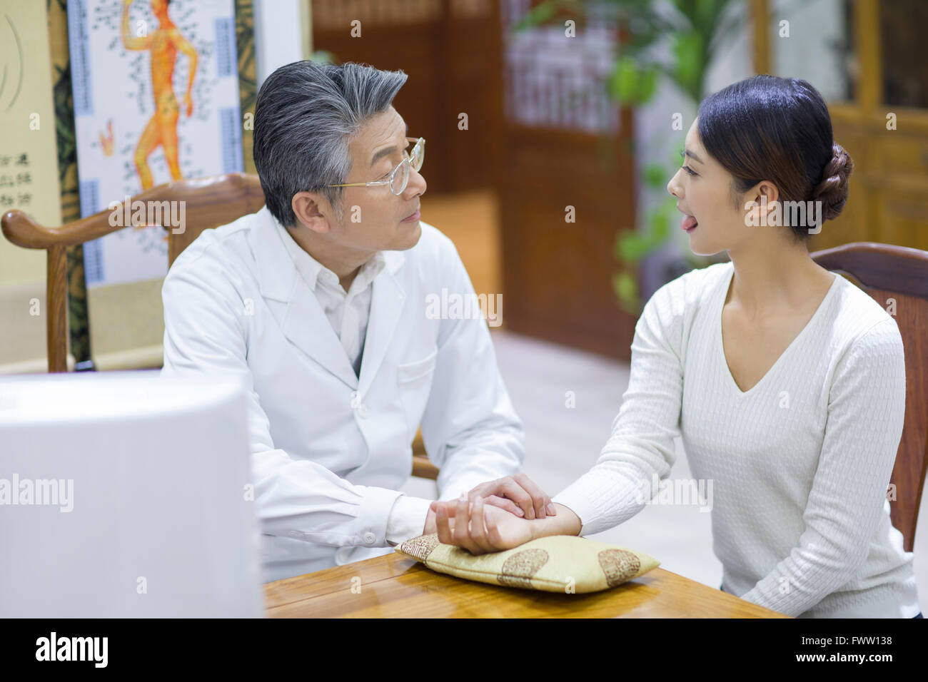 Senior Chinese doctor taking the pulse of patient Stock Photo - Alamy