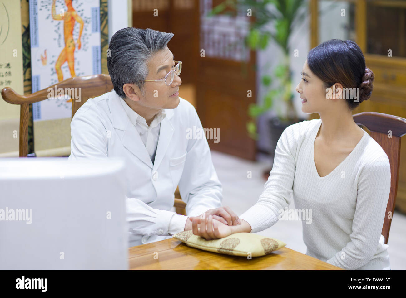 Senior Chinese doctor taking the pulse of patient Stock Photo - Alamy