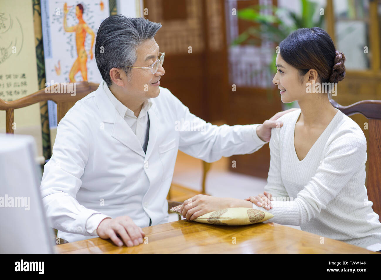 Senior Chinese doctor talking with patient Stock Photo - Alamy