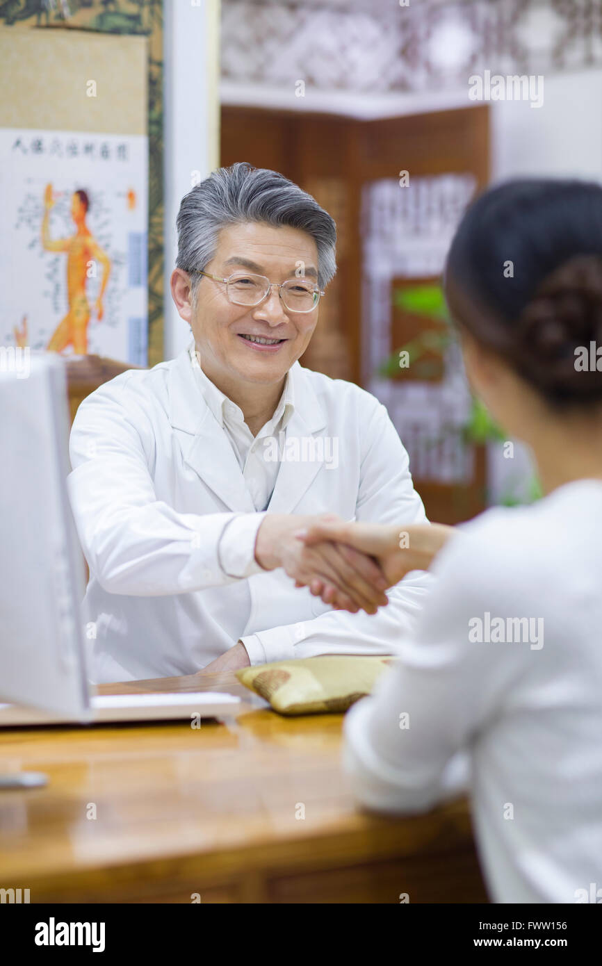 Senior Chinese doctor shaking hands with patient Stock Photo - Alamy