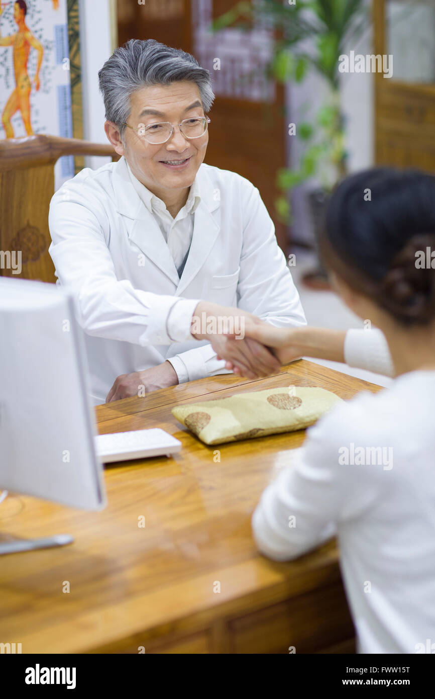 Senior Chinese doctor shaking hands with patient Stock Photo - Alamy