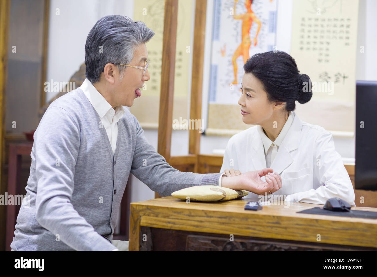 Female Chinese doctor taking the pulse of patient Stock Photo - Alamy