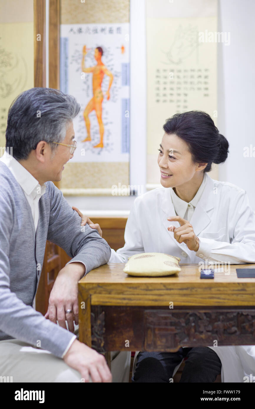 Female Chinese doctor talking with patient Stock Photo - Alamy