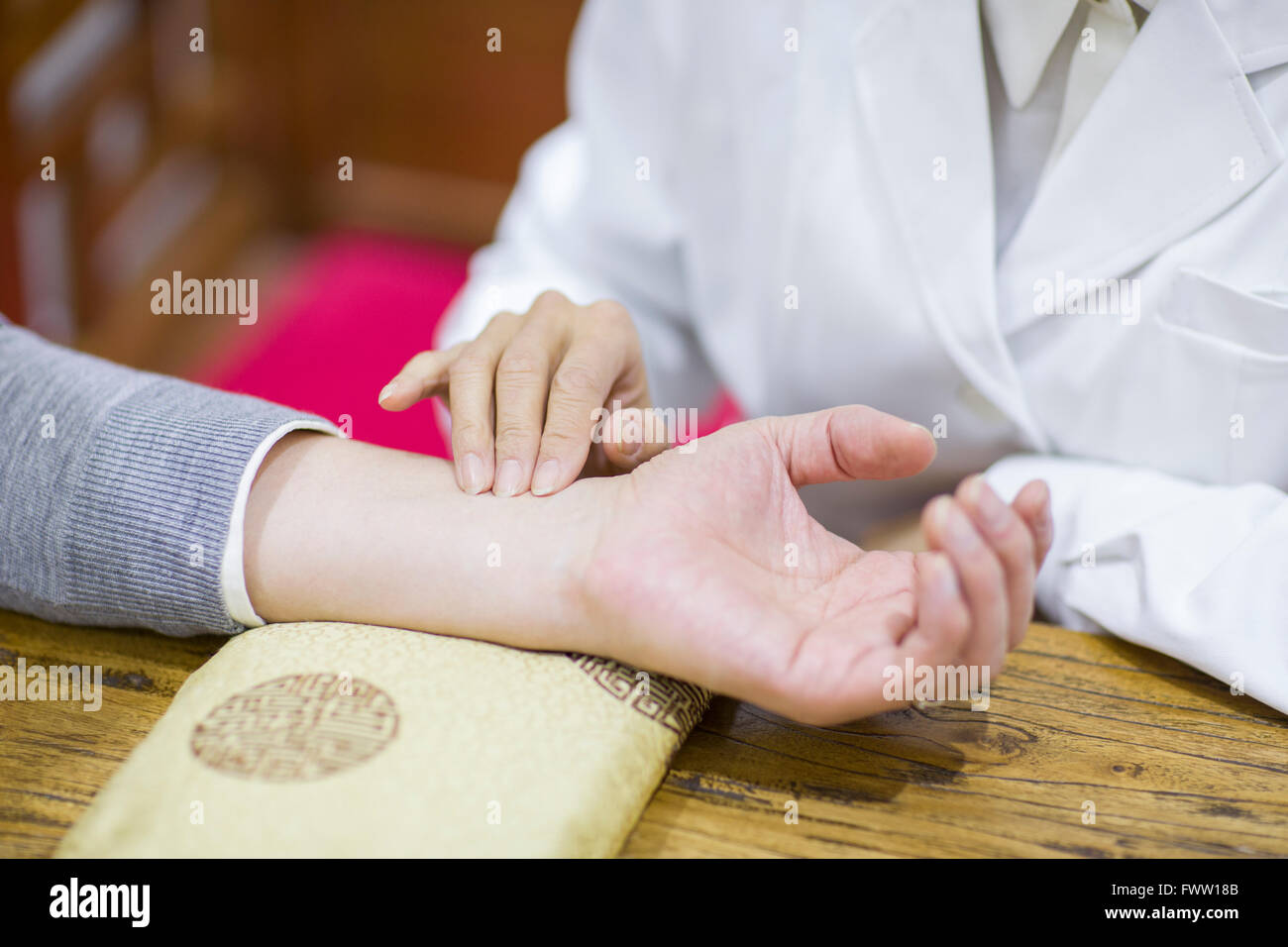 Female Chinese doctor taking the pulse of patient Stock Photo - Alamy