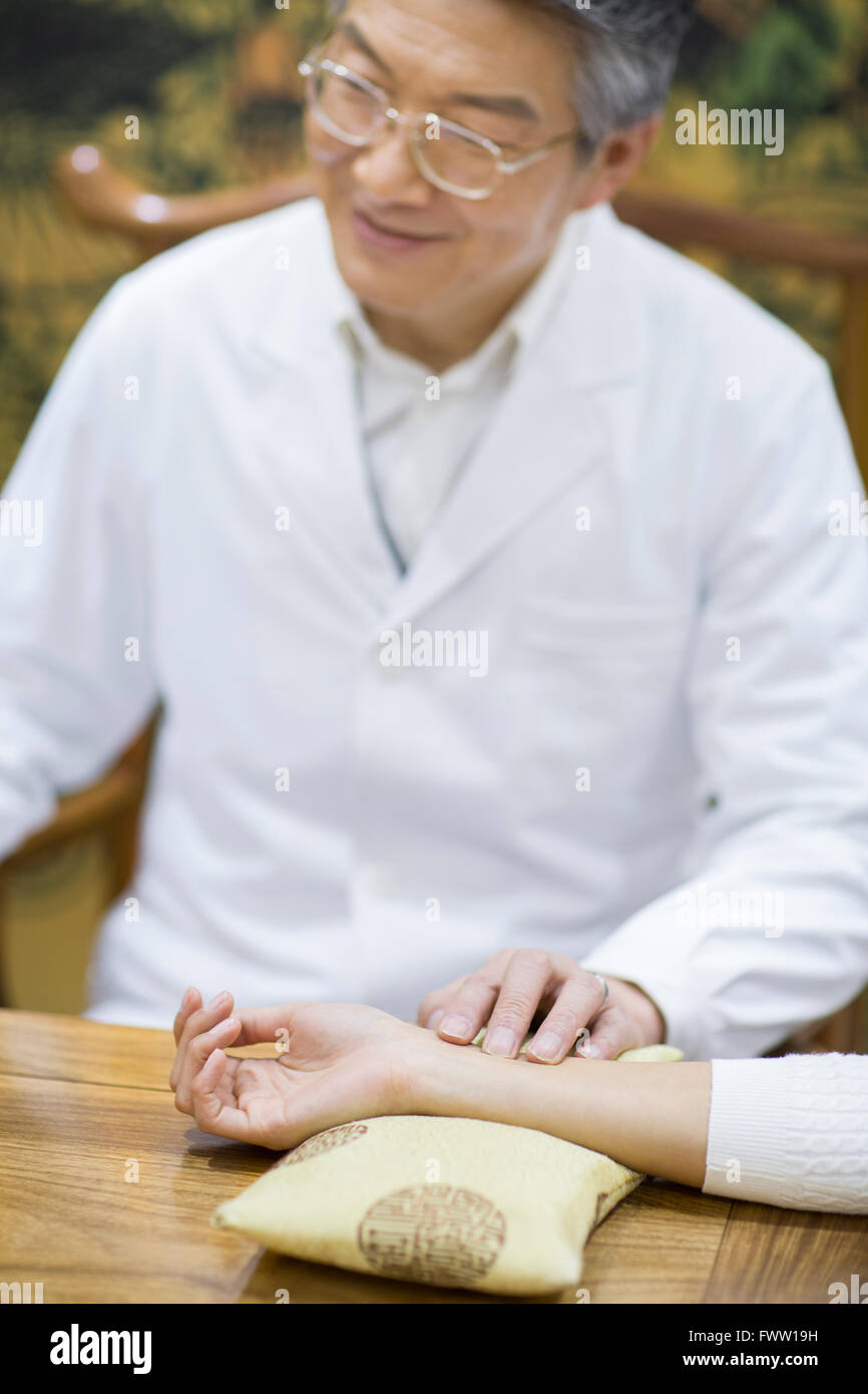 Senior Chinese doctor taking the pulse of patient Stock Photo - Alamy