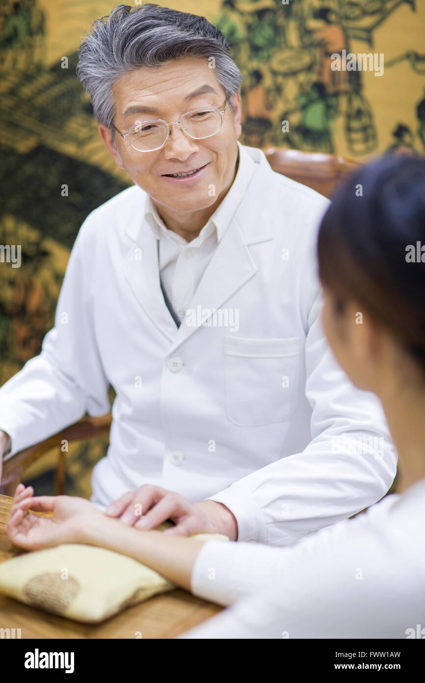 Senior Chinese doctor taking the pulse of patient Stock Photo - Alamy