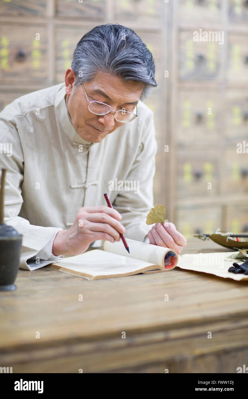 Senior Chinese doctor checking medicinal herbs Stock Photo - Alamy