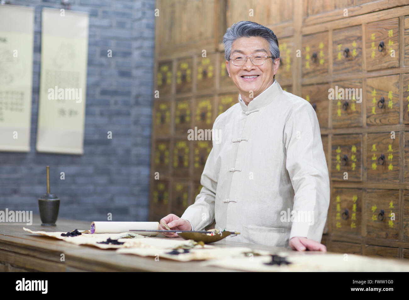 Senior Chinese doctor with various medicinal herbs Stock Photo - Alamy