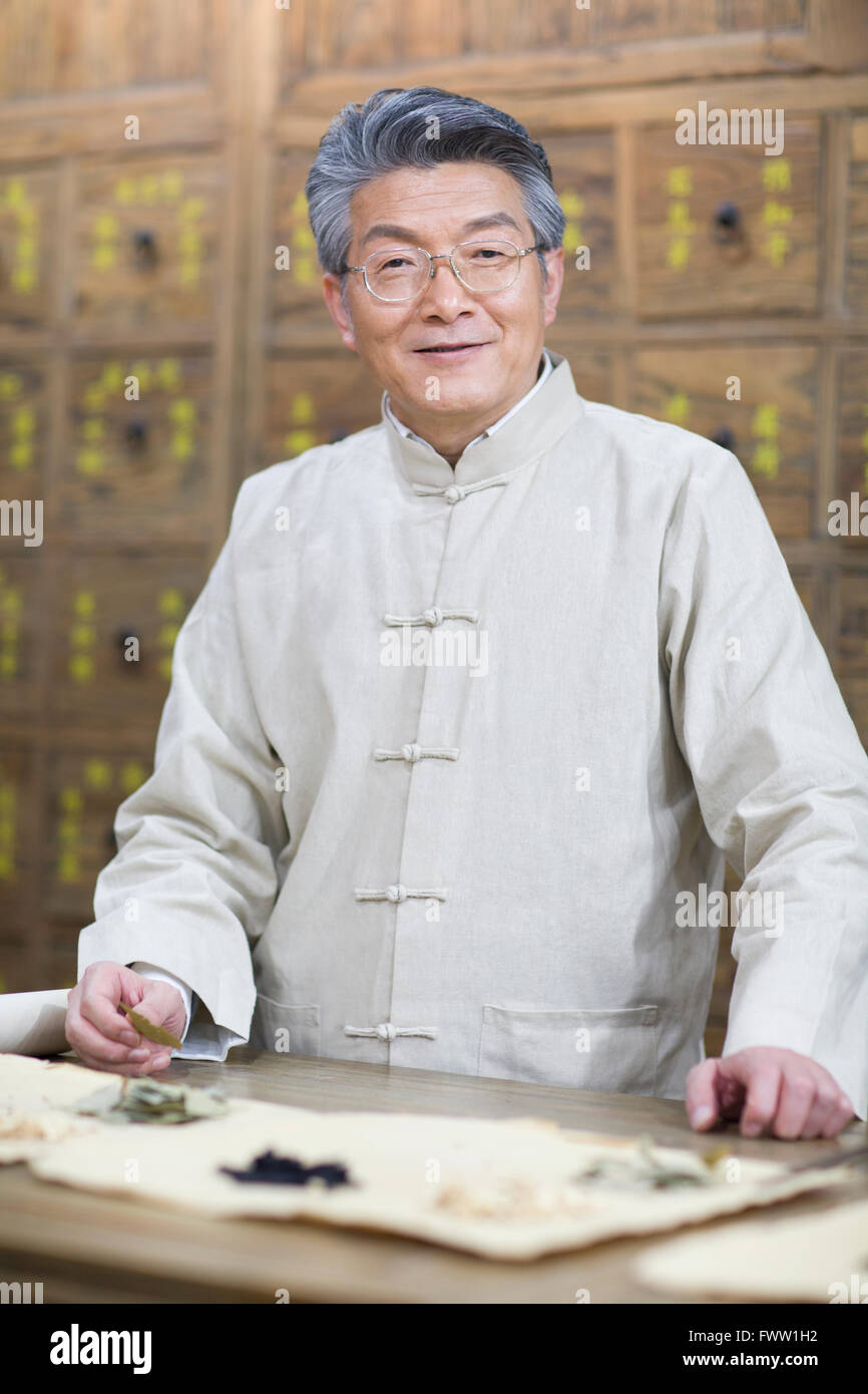 Senior Chinese doctor with various medicinal herbs Stock Photo - Alamy