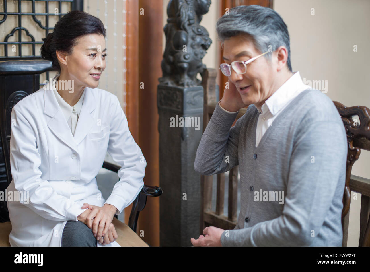 Female Chinese doctor talking with patient Stock Photo - Alamy