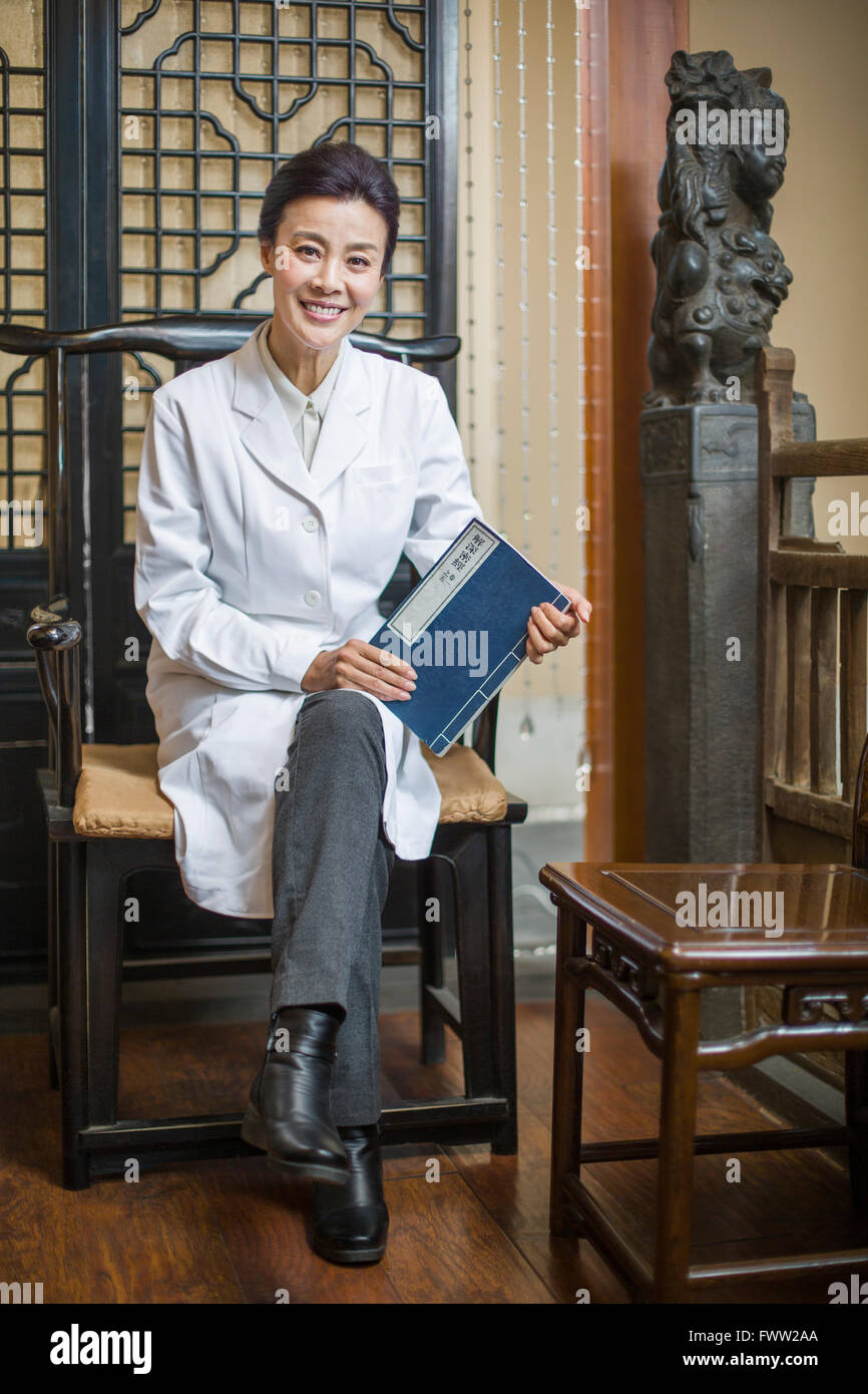 Female Chinese doctor holding a book Stock Photo - Alamy