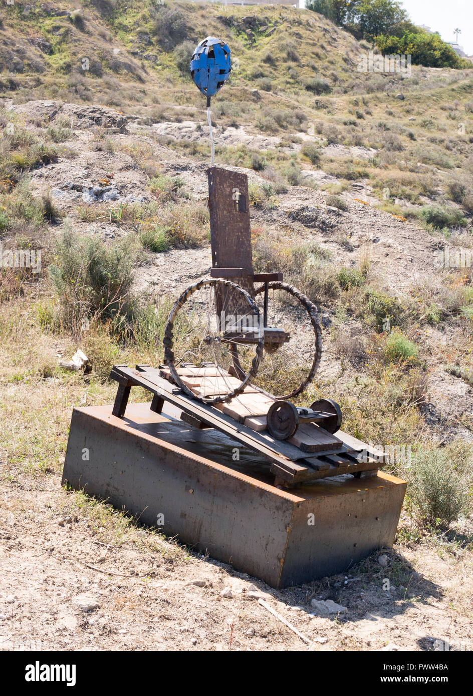 rusty wheelchair art with blue metal balloon in a field in Spain Stock ...