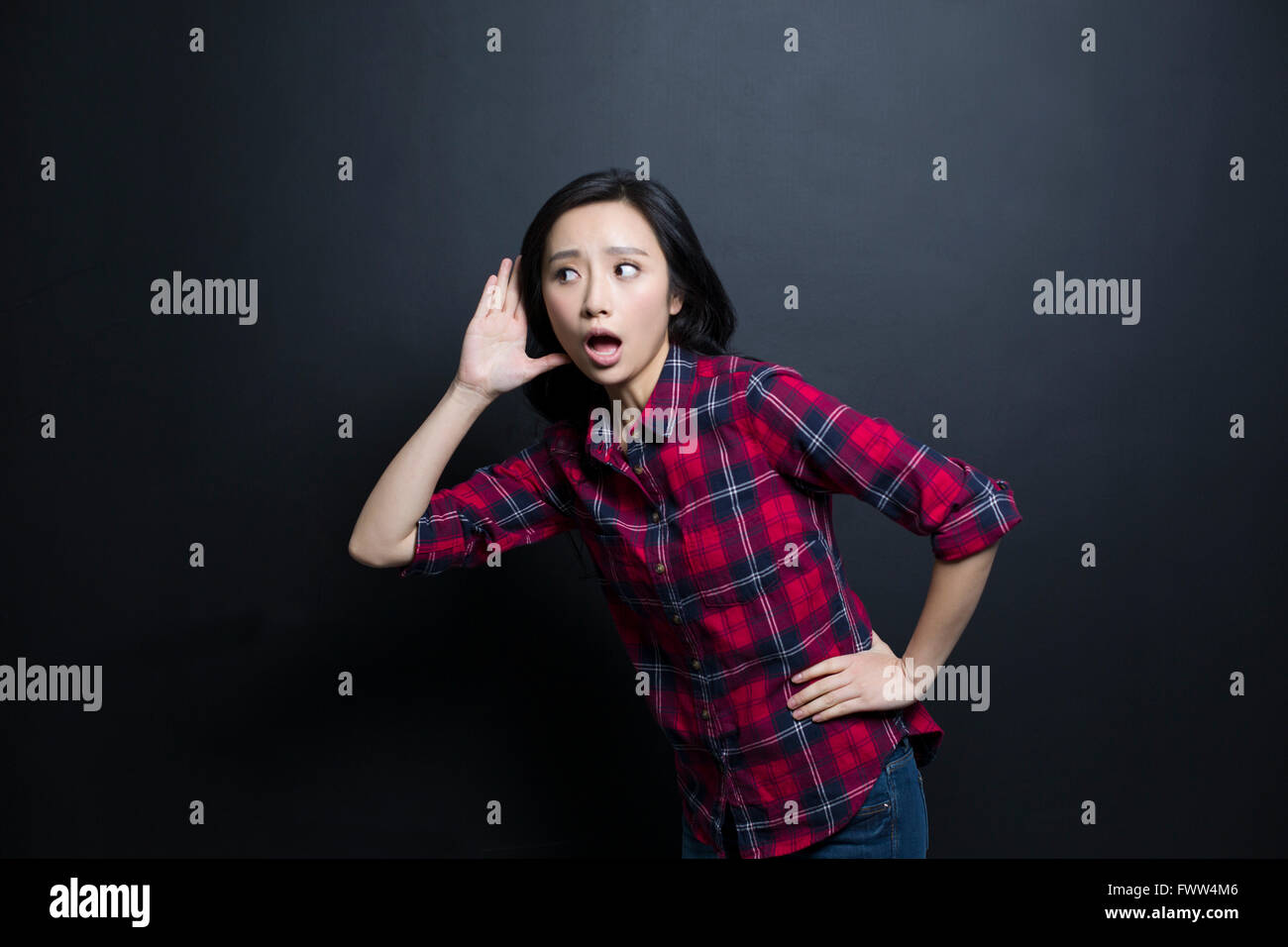 Young woman eavesdropping Stock Photo - Alamy