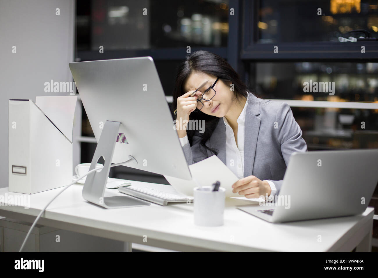 Businesswoman working late in office Stock Photo - Alamy