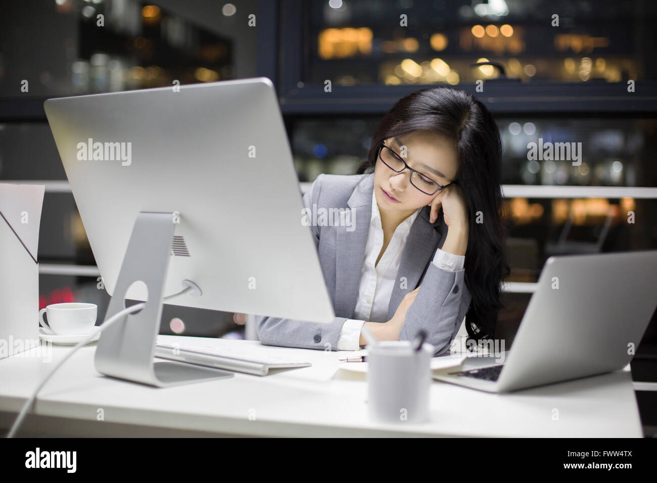 Businesswoman working late in office Stock Photo - Alamy