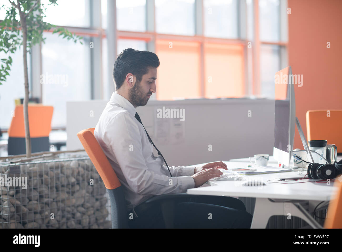 happy young business man working on desktop computer at his desk in ...