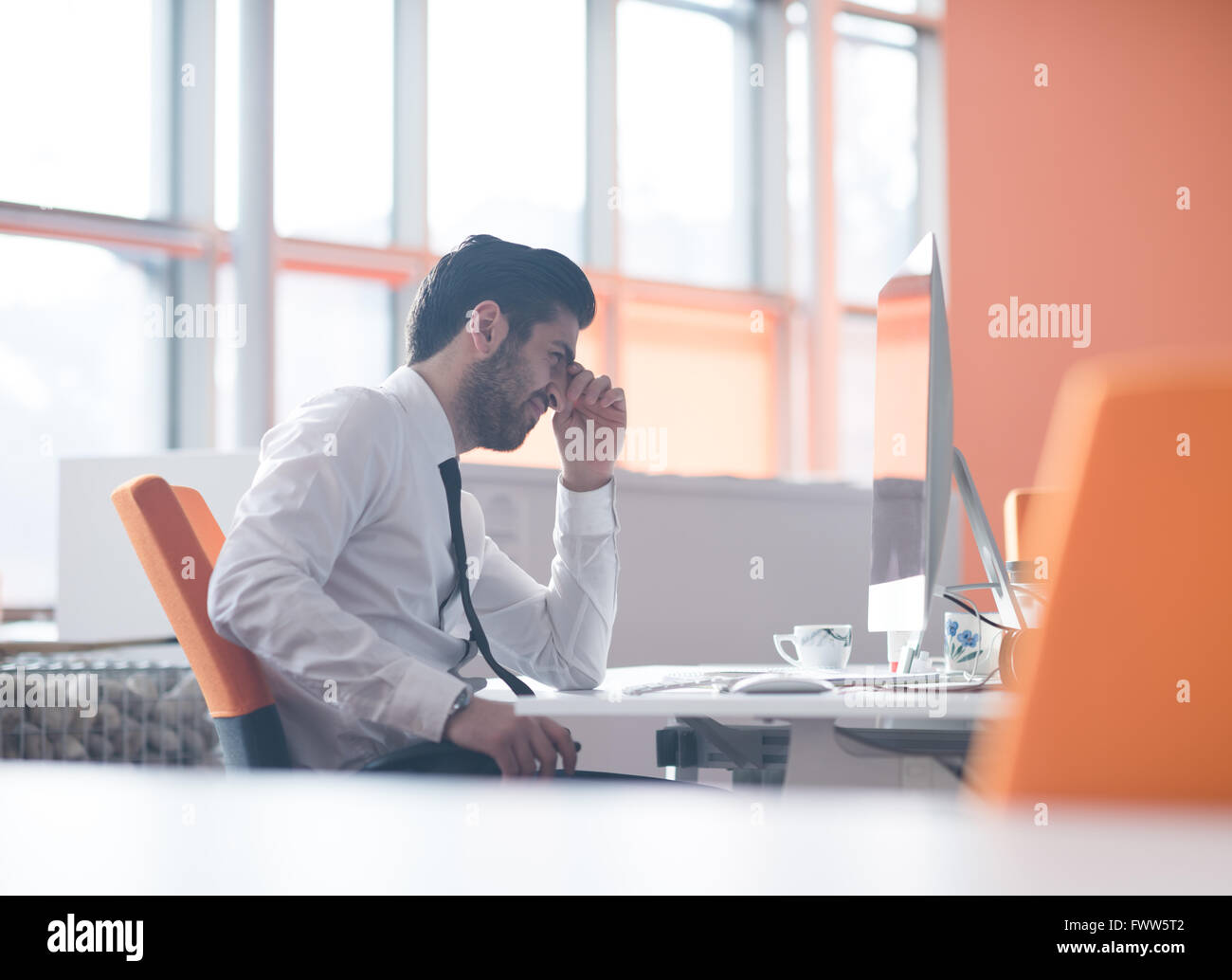 frustrated young business man working on desktop computer at modern ...