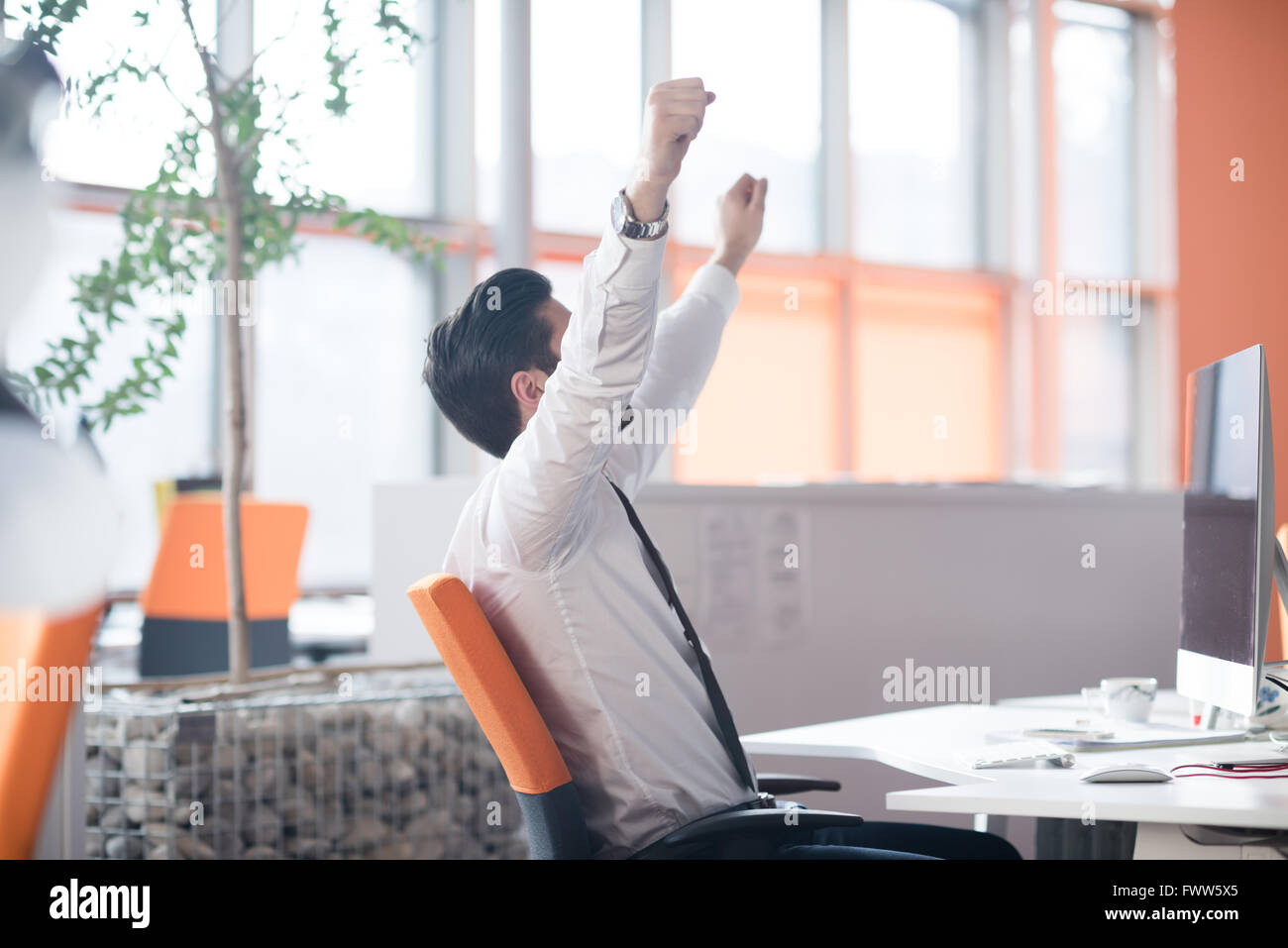 happy young business man working on desktop computer at his desk in ...