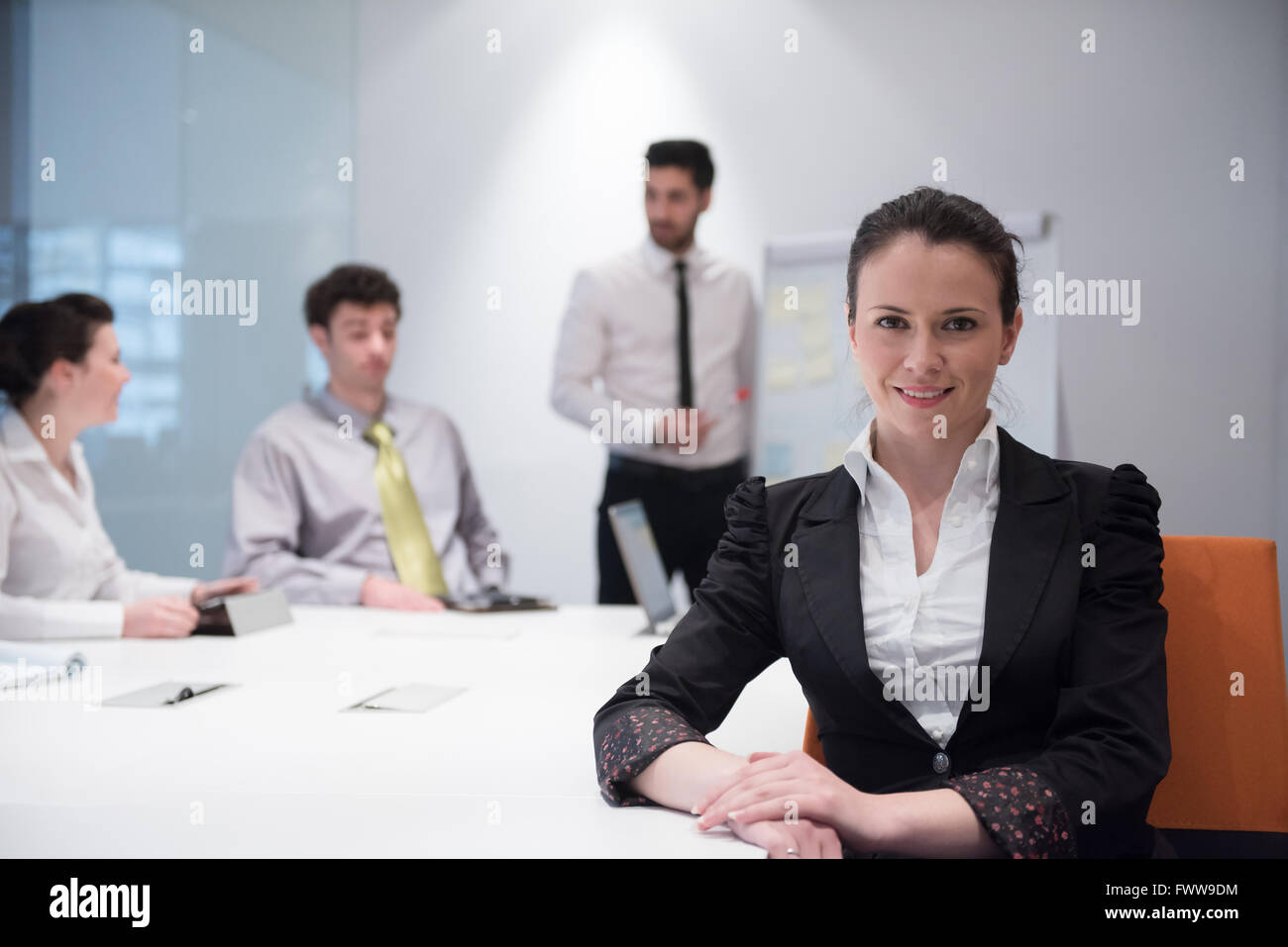 young business woman on meeting usineg laptop computer, blured group of ...